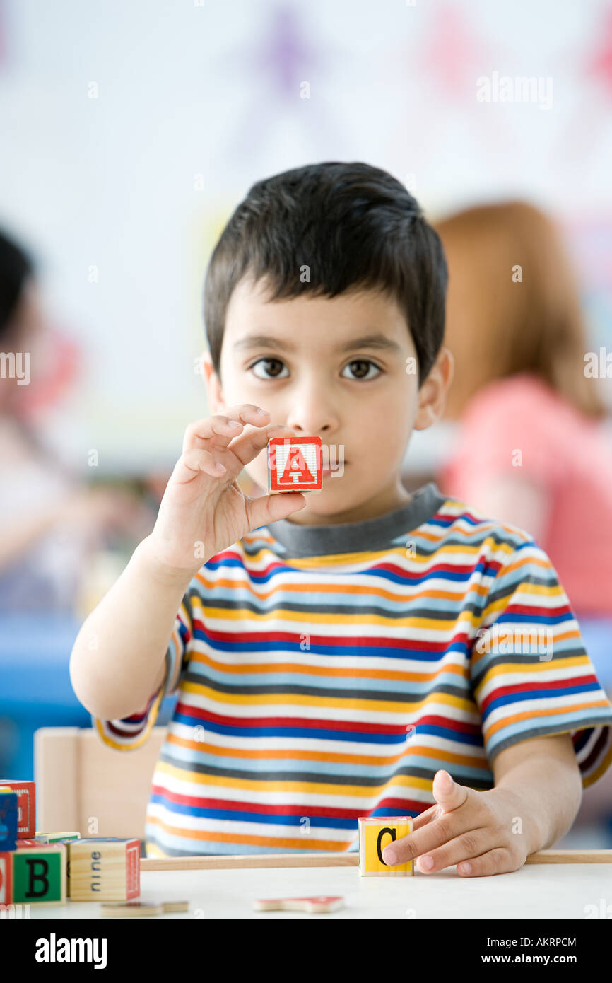 A boy holding a building block Stock Photo - Alamy