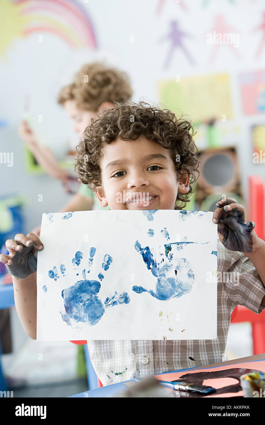 Boy holding up painted hand print Stock Photo - Alamy