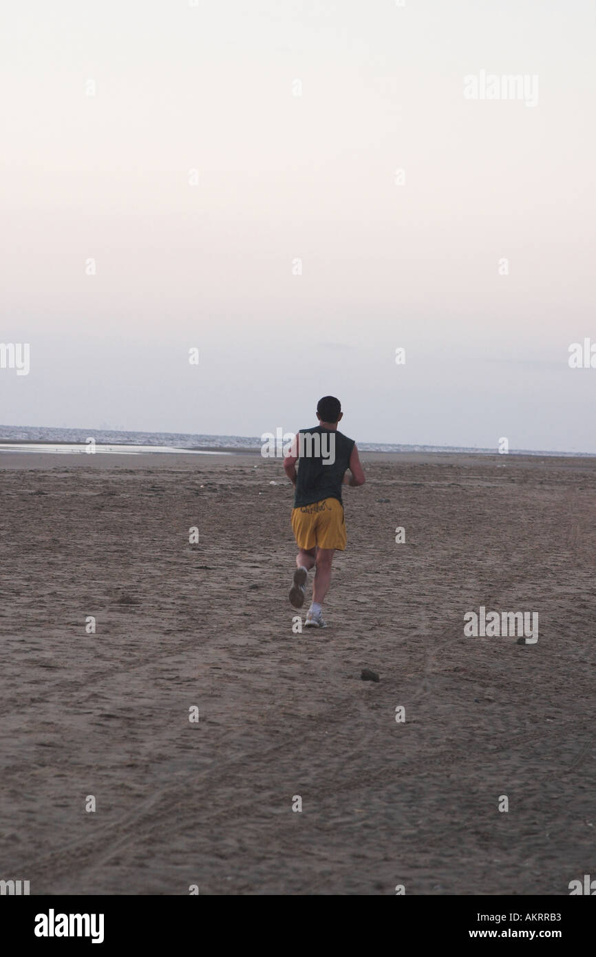 man running at sunset along a beach Stock Photo - Alamy
