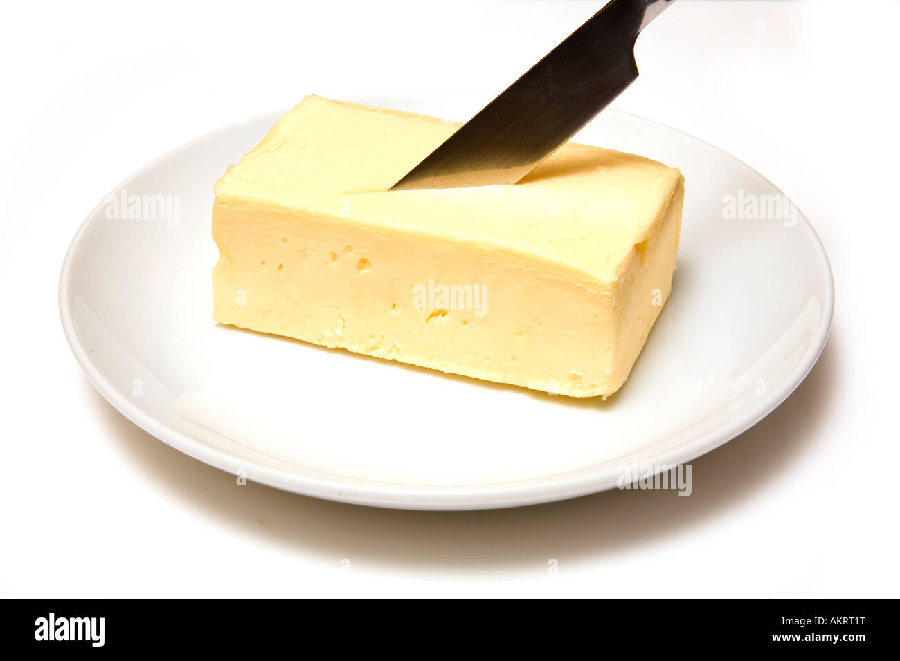 Slab of traditional butter with a table knife isolated on a white ...