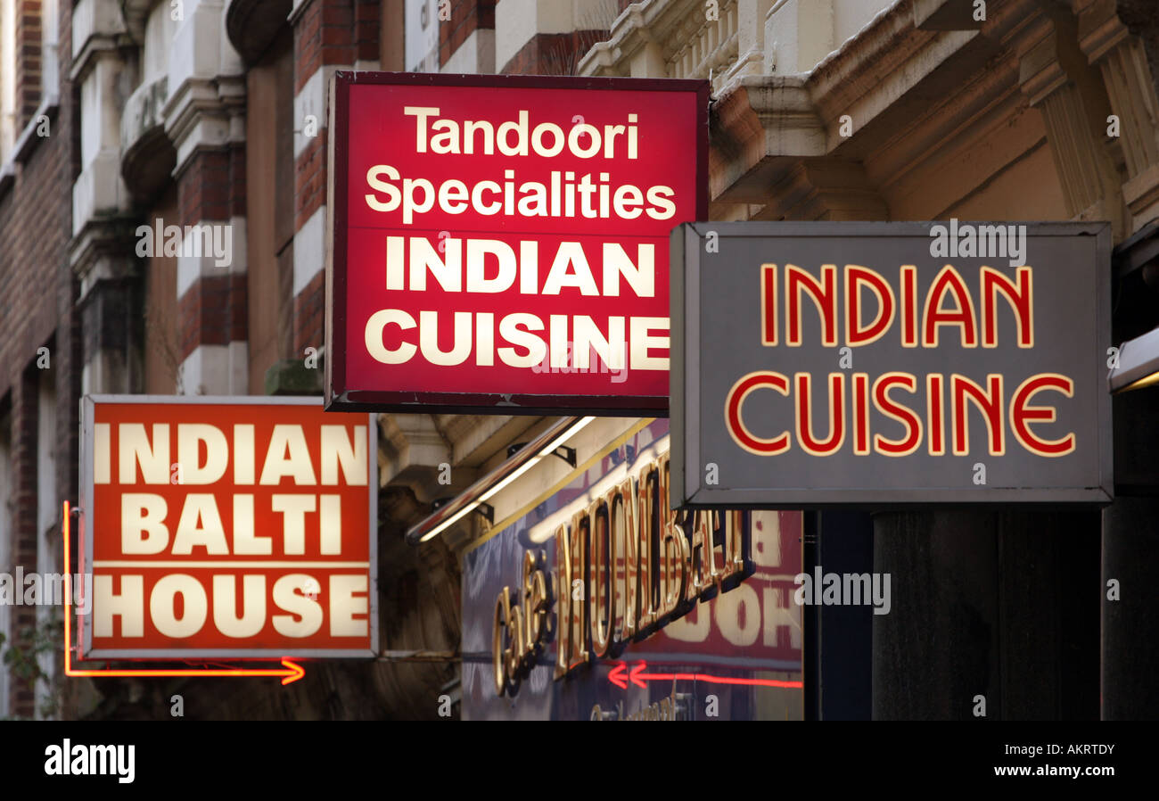 A GV of sign advertising curry houses on a street in London, Engalnd ...