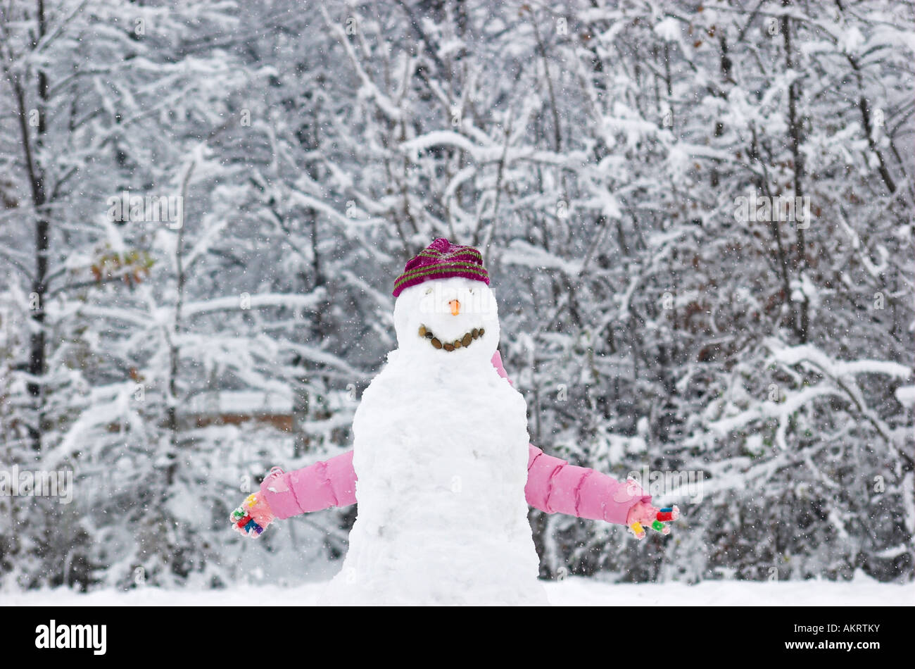 Girl standing behind snowman with open arms Stock Photo - Alamy