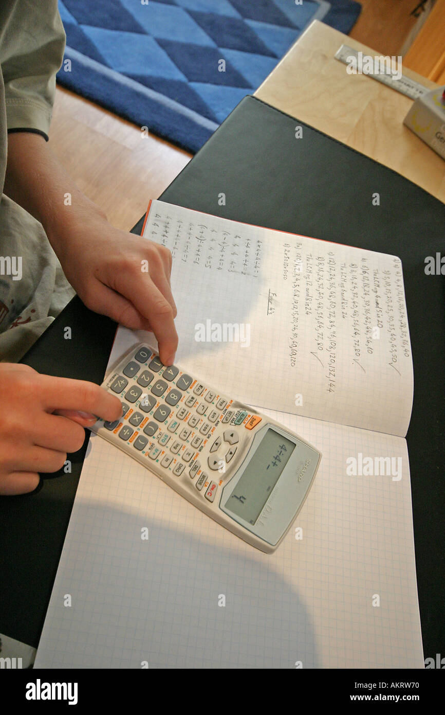 boy doing maths with his calculator in his bedroom Stock Photo - Alamy
