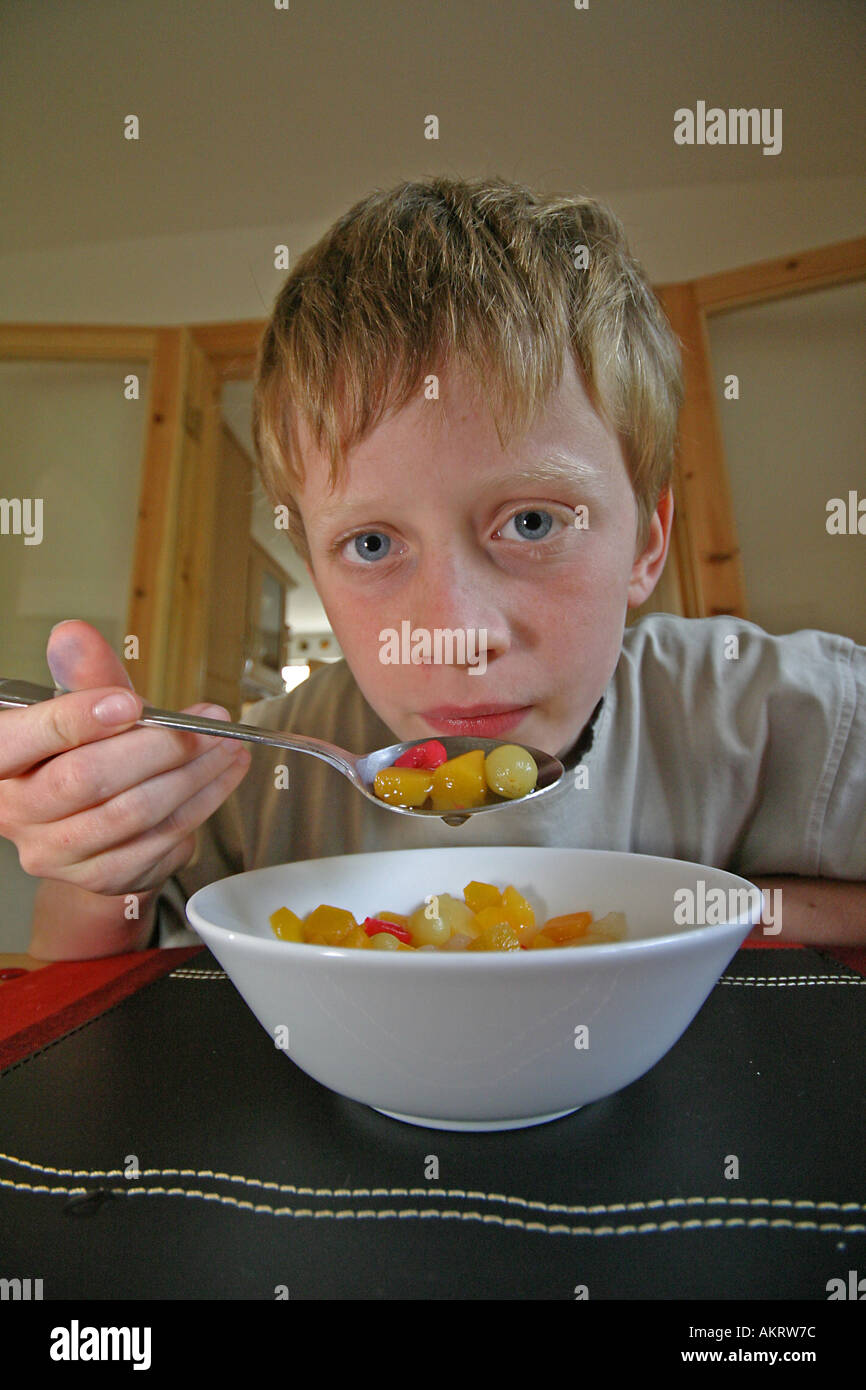 boy eating fruit from a bowl at home Stock Photo - Alamy