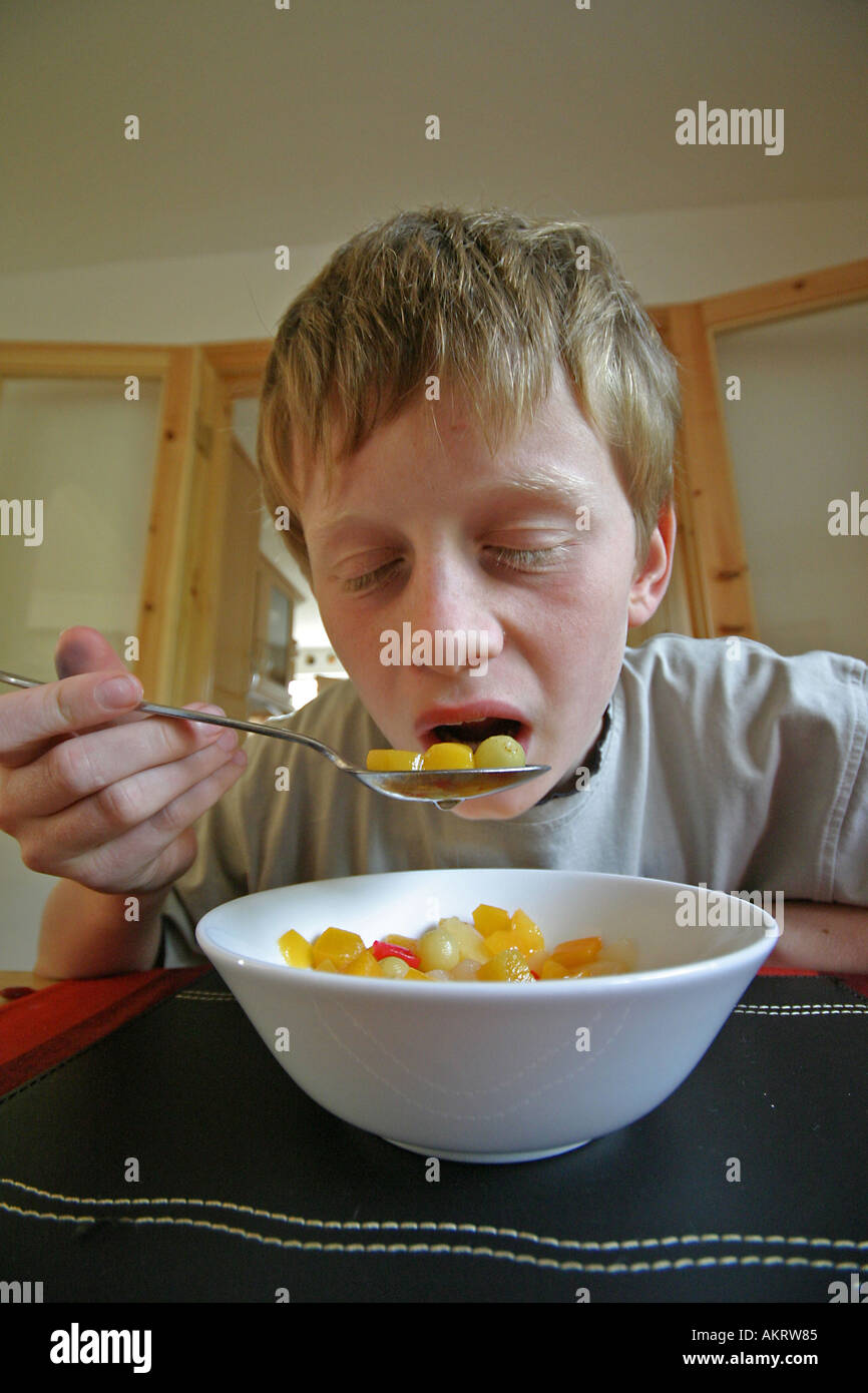 boy eating fruit from a bowl at home Stock Photo - Alamy
