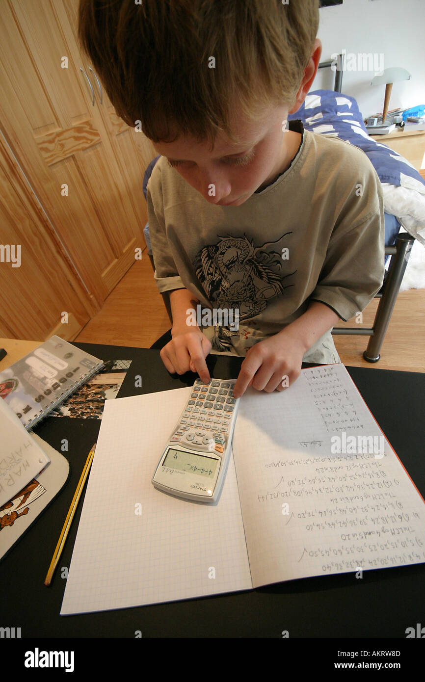 boy using calulator to do maths homework Stock Photo - Alamy