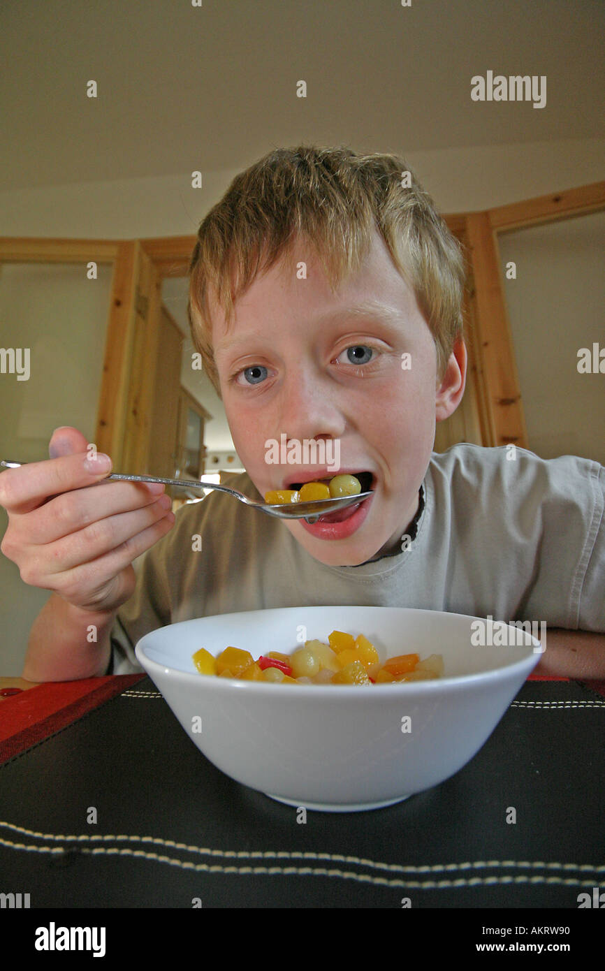boy eating fruit from a bowl at home Stock Photo - Alamy