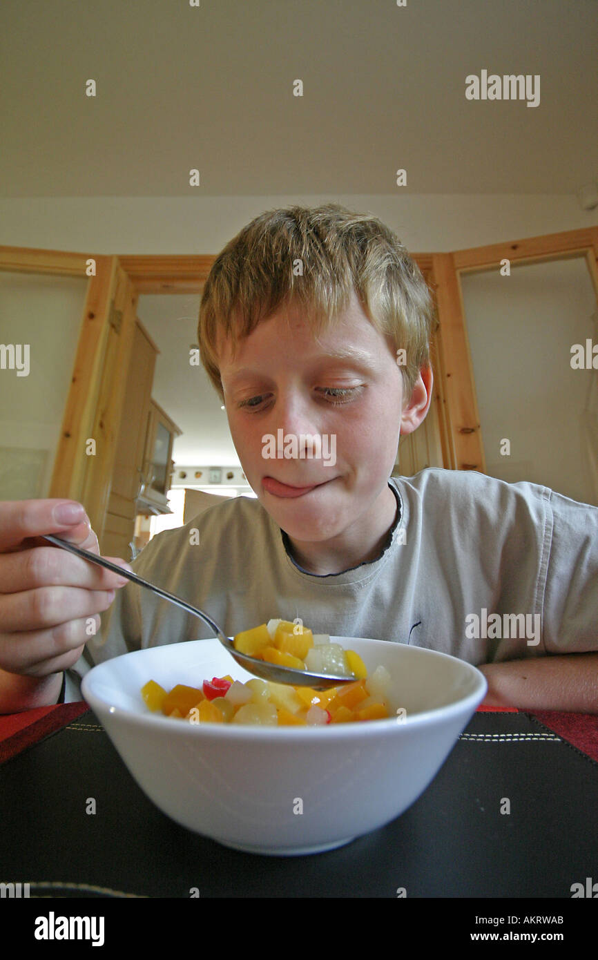 boy eating fruit from a bowl at home Stock Photo - Alamy