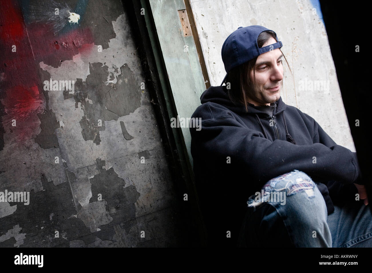 Man sitting in worn out clothing Stock Photo - Alamy