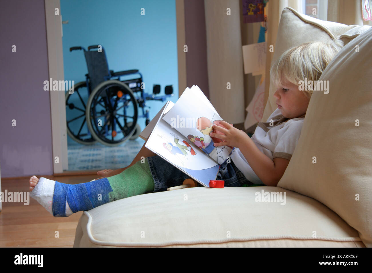 Little boy with a broken leg reading a book Stock Photo - Alamy