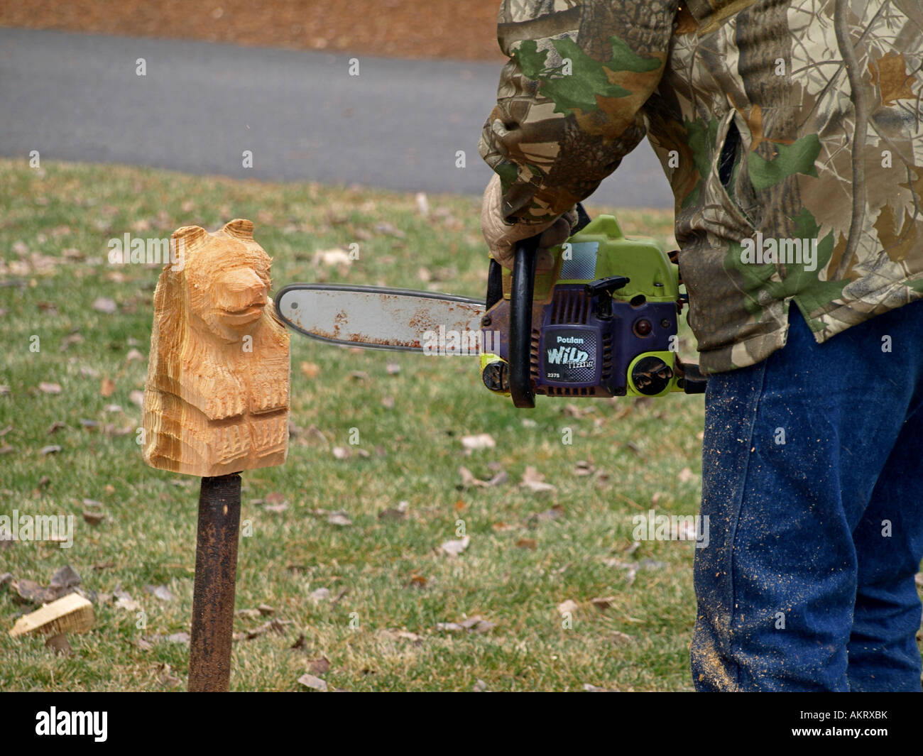 A chainsaw artist creates a small wooden bear in a demonstration at a ...