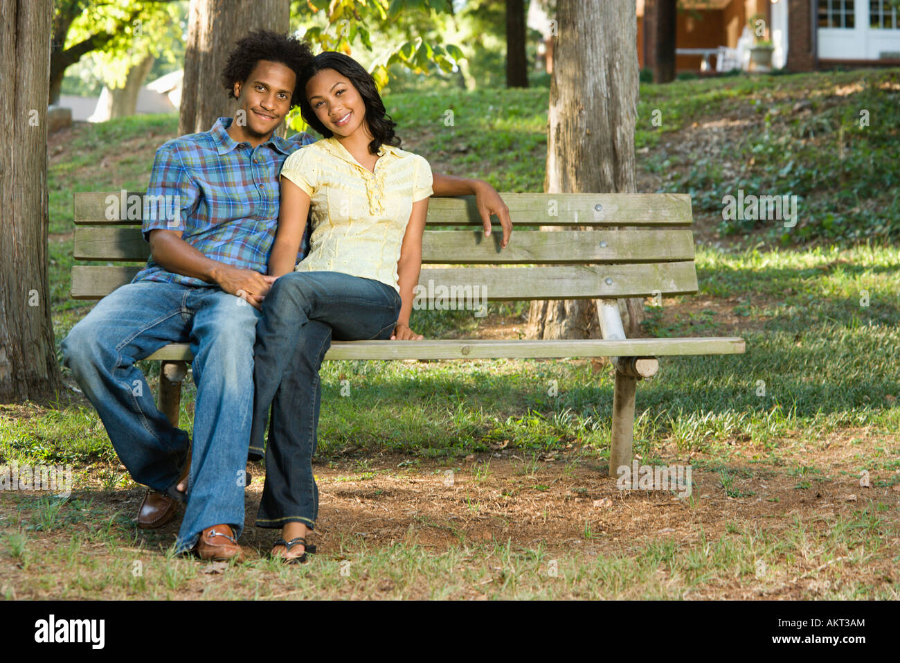 Happy smiling couple sitting on park bench together Stock Photo - Alamy