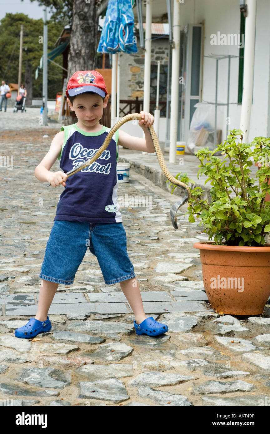 Impish young boy (4-5 yrs) having fun in the sun while playing in a ...