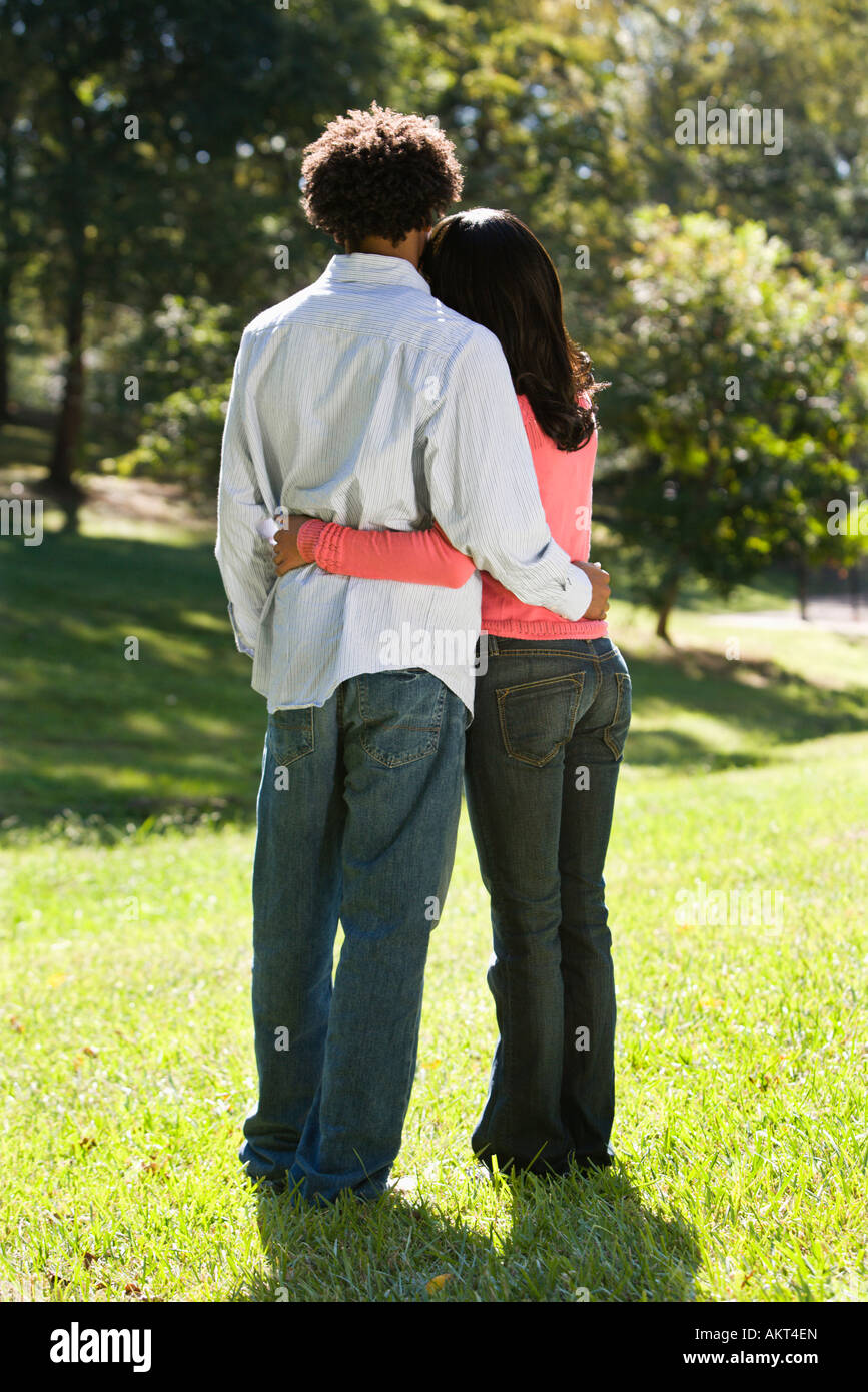 Rear view of couple standing in park with arms around eachother Stock ...