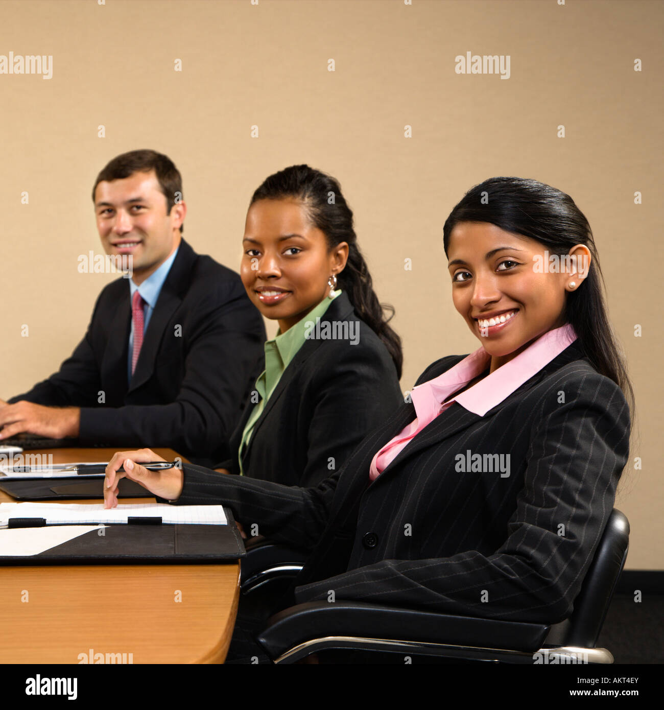 Businesspeople sitting at conference table smiling Stock Photo - Alamy