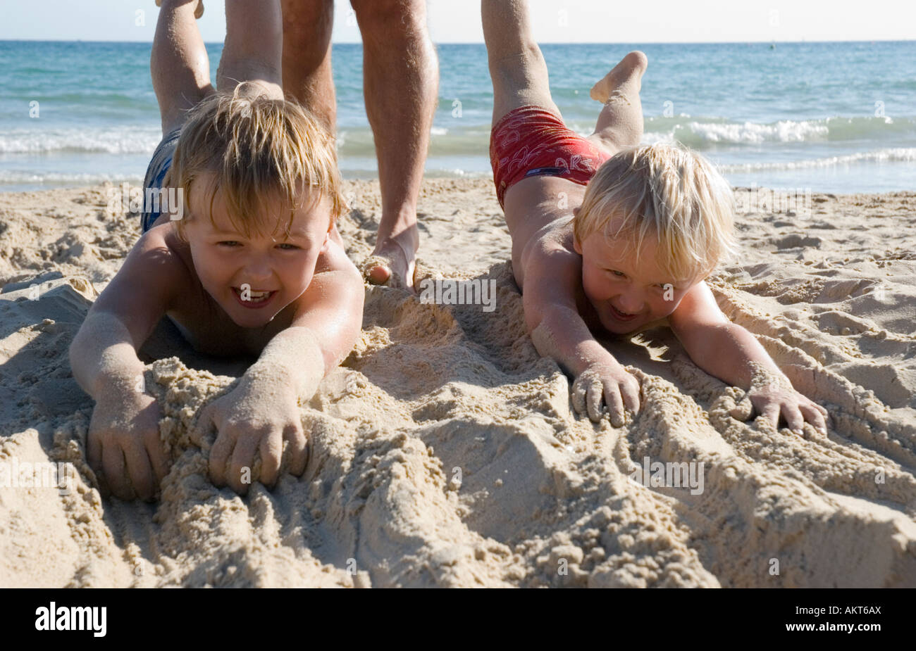 Colour landscape of two young boys playing on the beach with their ...