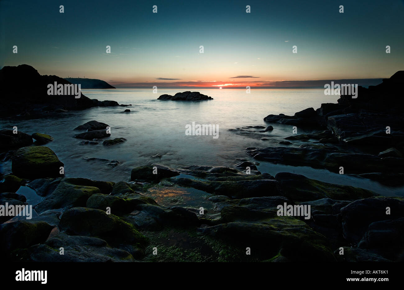 Sunset across rocksand rock pools at Tresaith beach in west wales UK ...