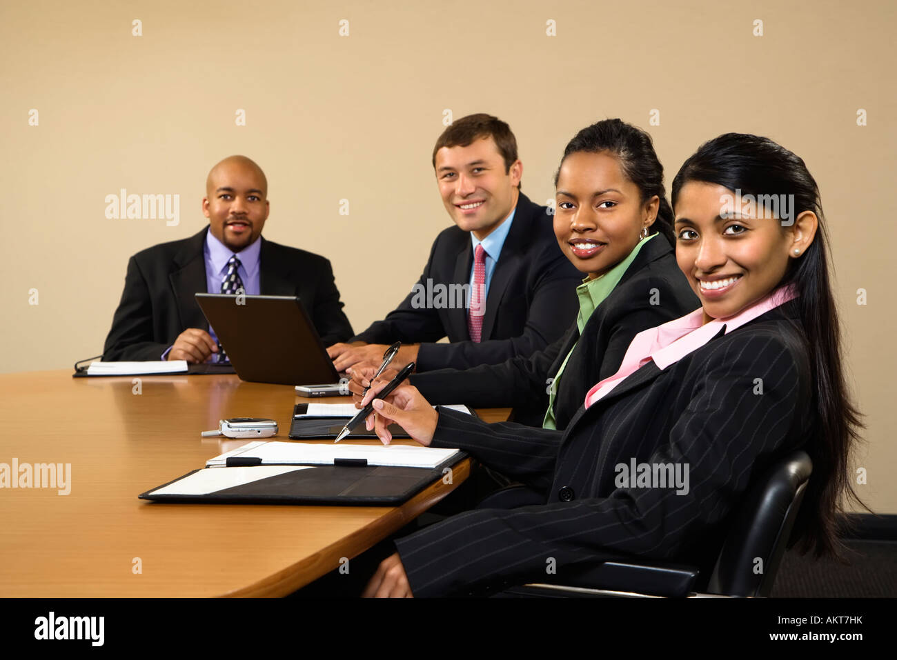 Businesspeople sitting at conference table smiling Stock Photo - Alamy