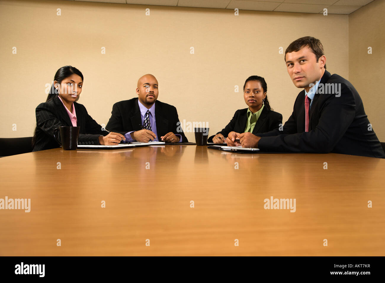 Businesspeople sitting at conference table Stock Photo - Alamy