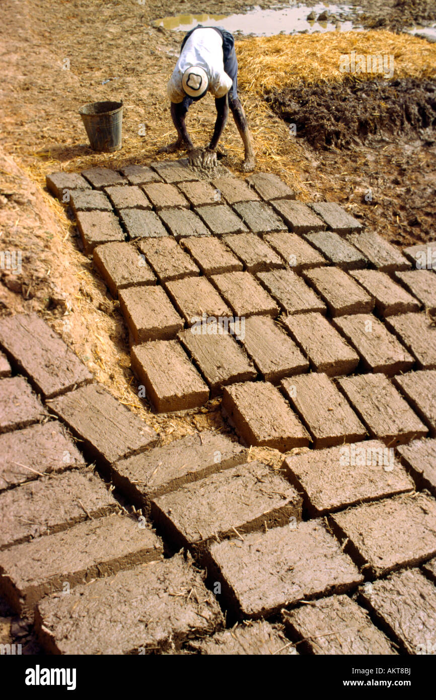 A man manually molds bricks from clay and straw on the banks of the ...