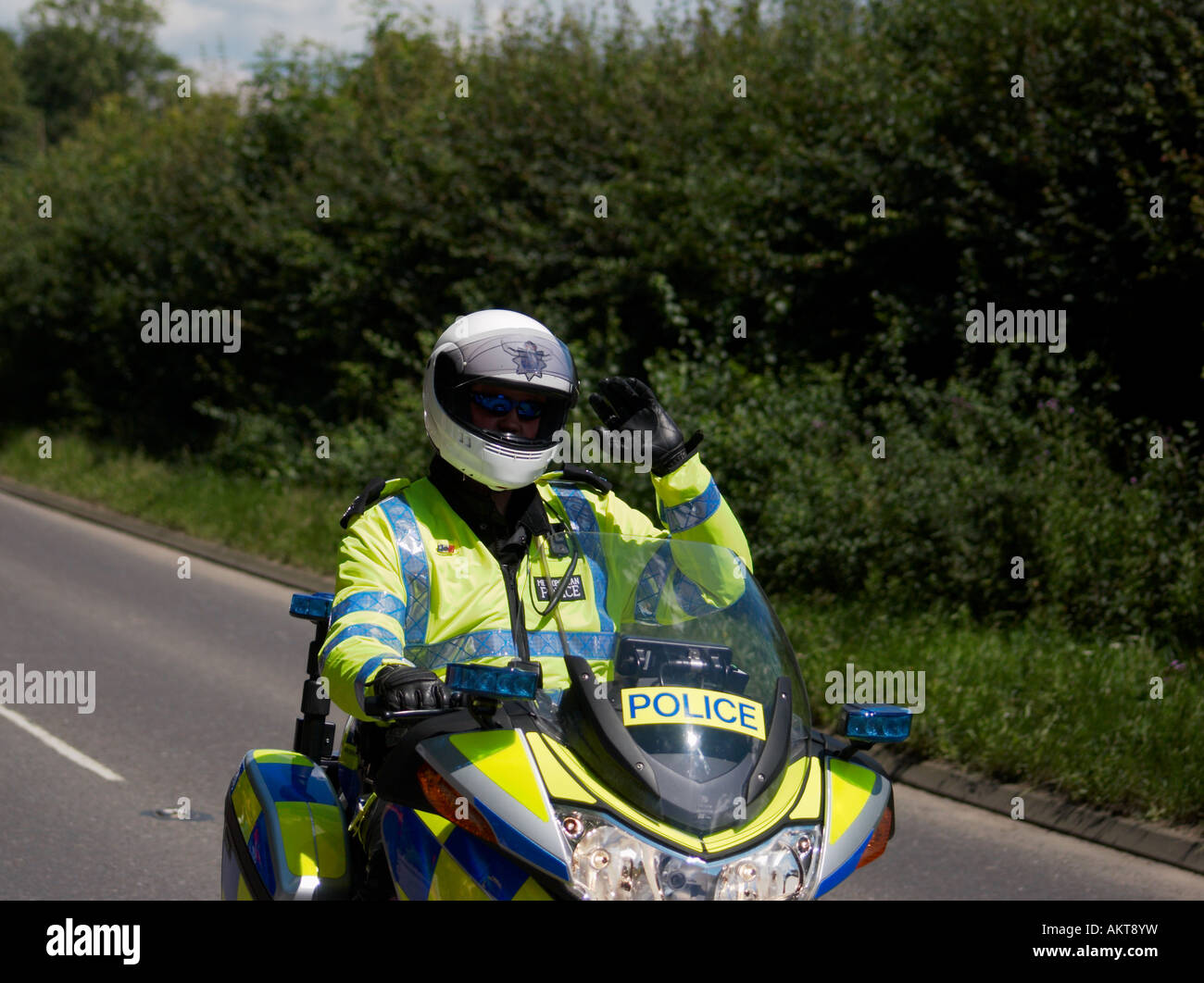 Police Motorcyclist giving a friendly wave to the photographer ahead of ...