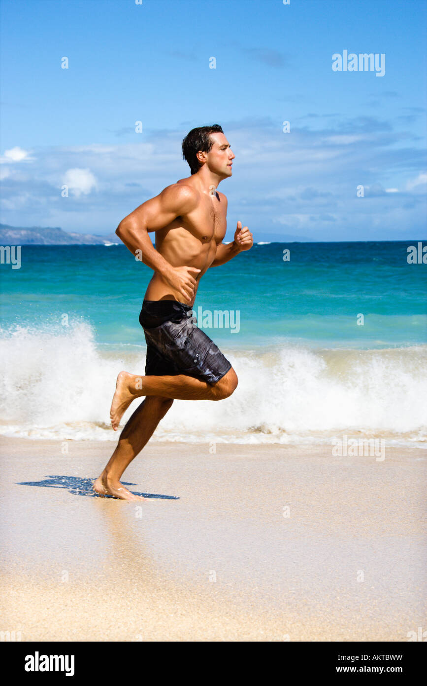 Physically fit man running on Maui Hawaii beach Stock Photo - Alamy