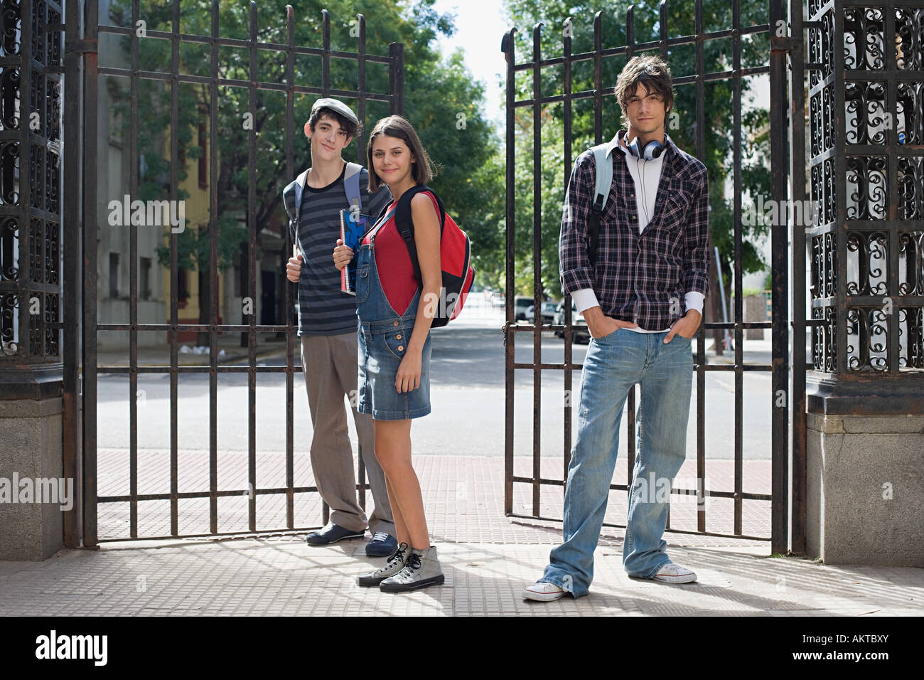 Three high school students near a gate Stock Photo - Alamy