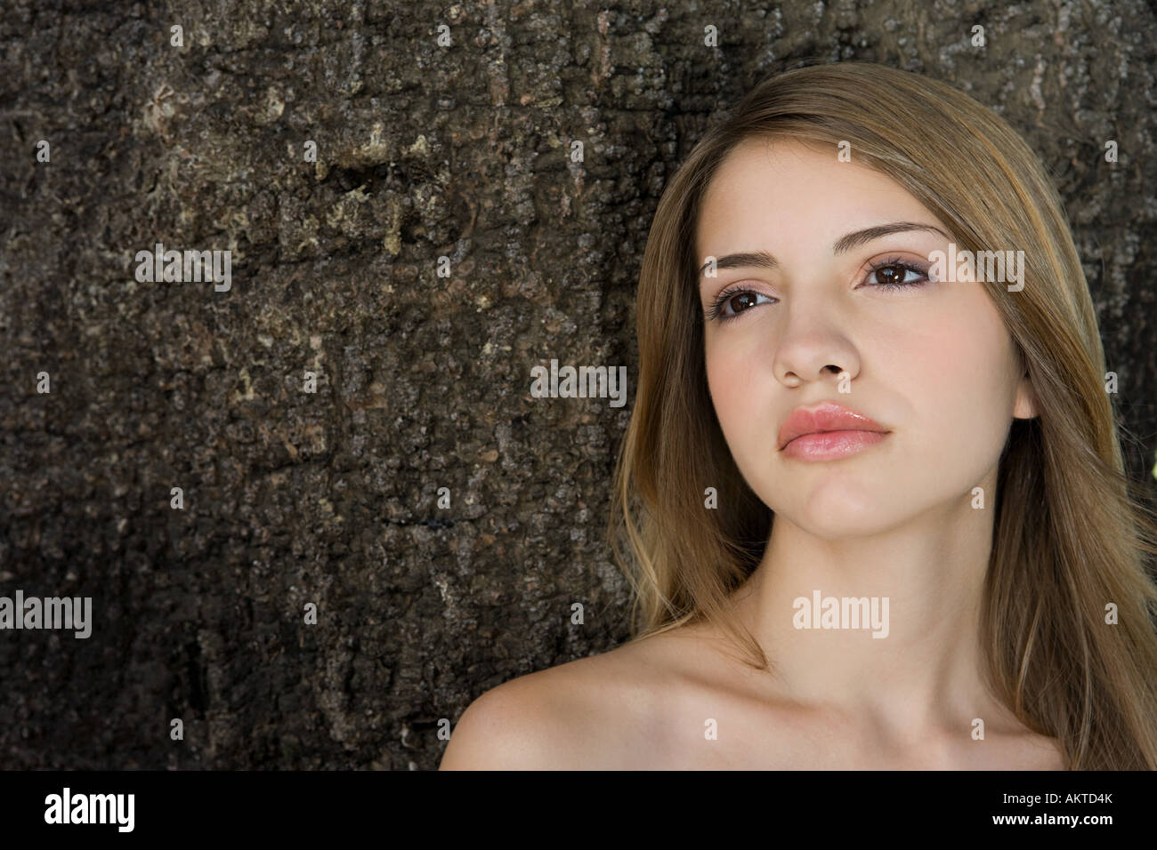 Beautiful young woman by tree Stock Photo - Alamy