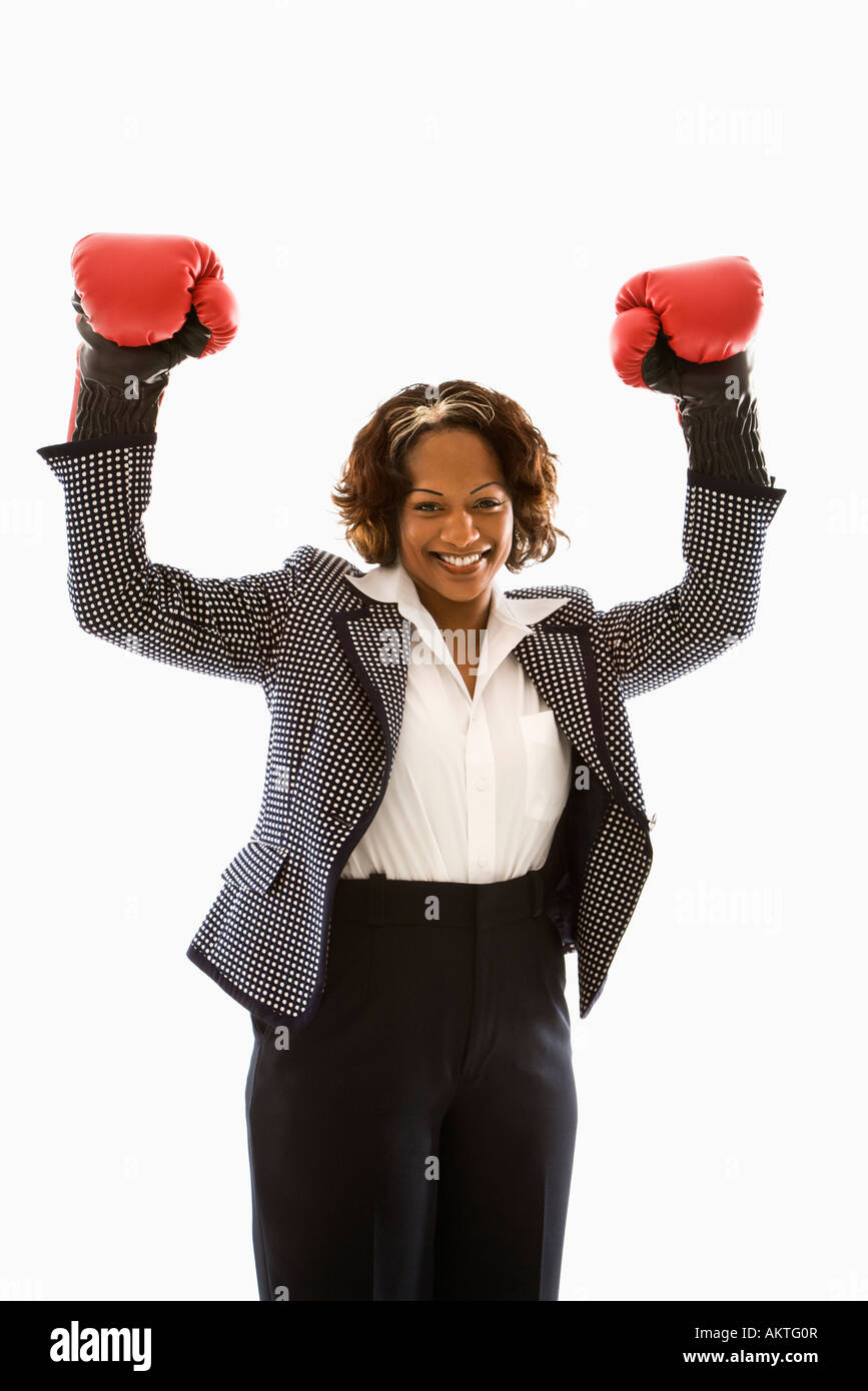 Businesswoman wearing boxing gloves holding arms up in victory stance ...