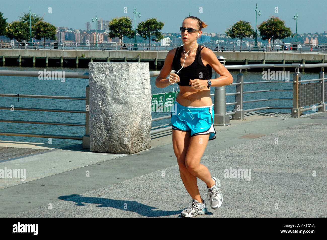 Joggers run by the Hudson River in Hudson River Park in NYC Stock Photo ...