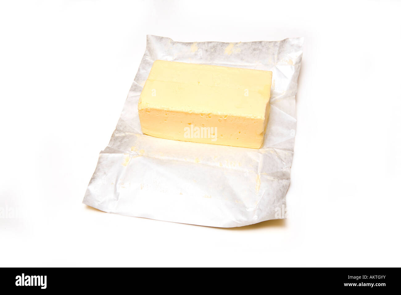Slab of butter with foil wrapper isolated on a white studio background ...