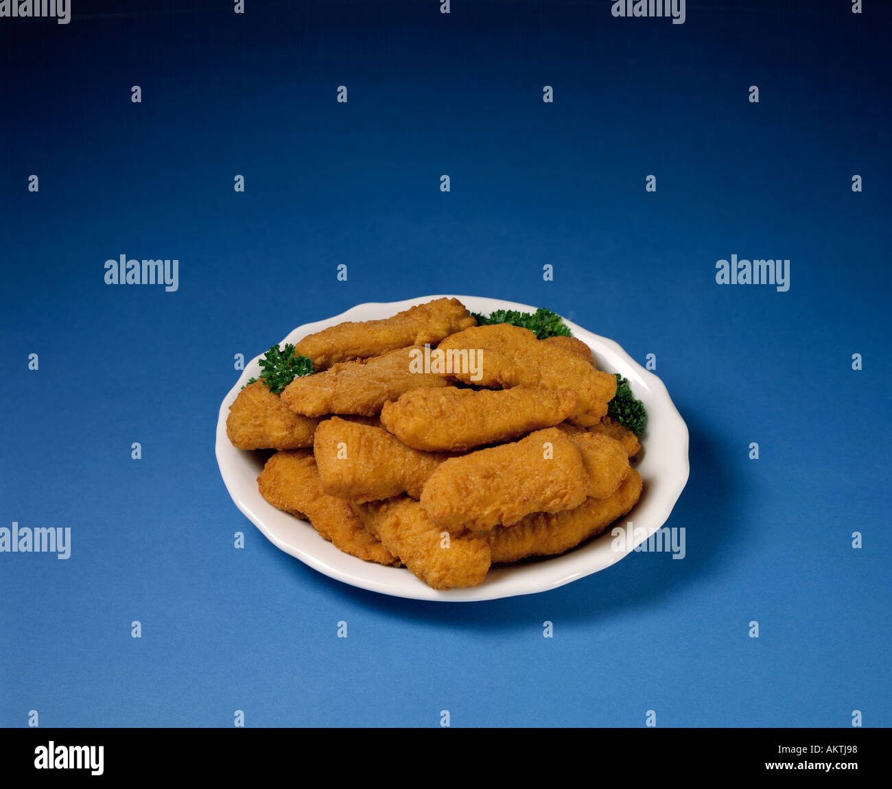 fried battered chicken strips on white serving platter plate Bon ...