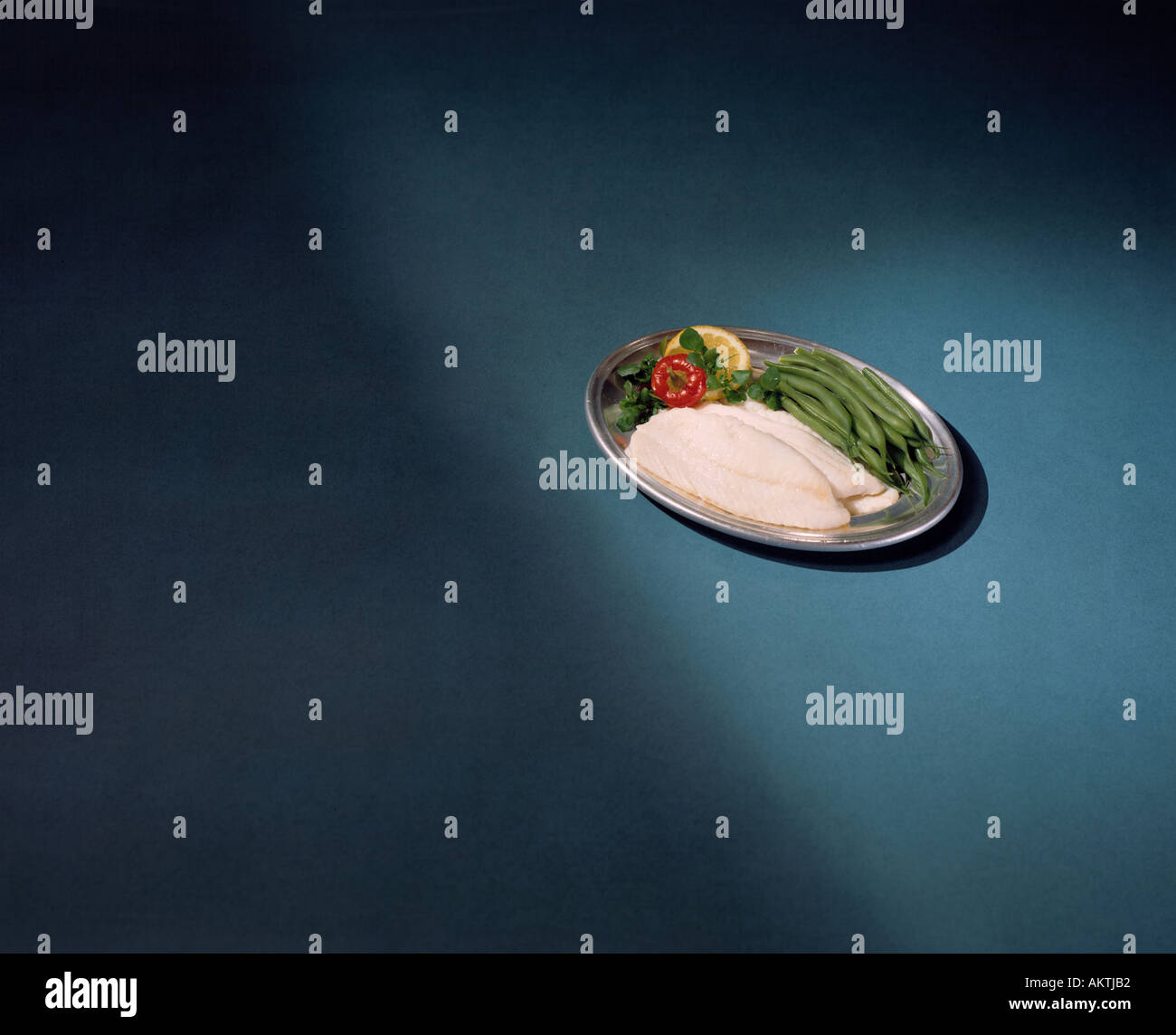 fish filet's pewter serving dish green string beans lemon wedge garnish ...