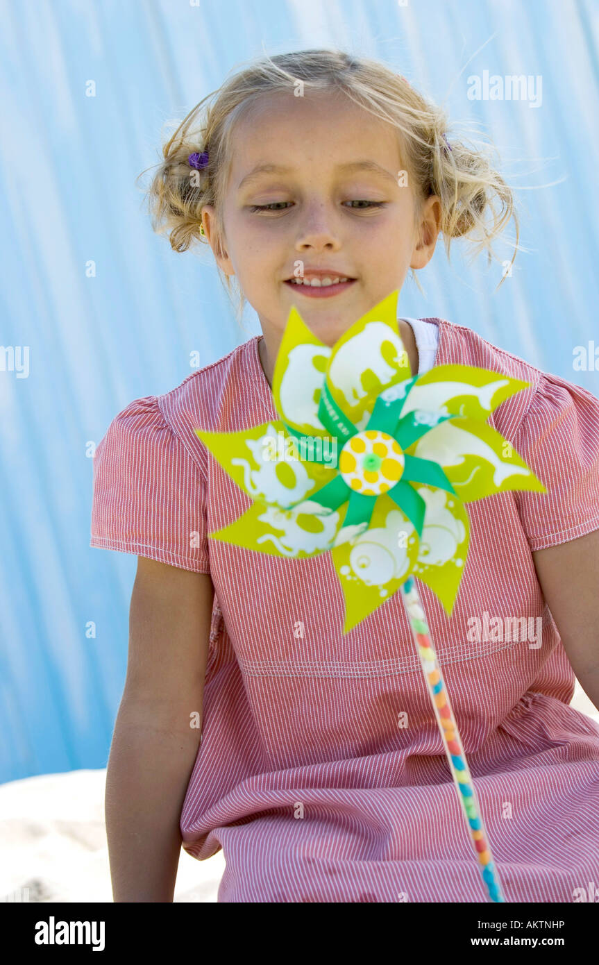 Young girl blowing pin wheel, side view Stock Photo - Alamy