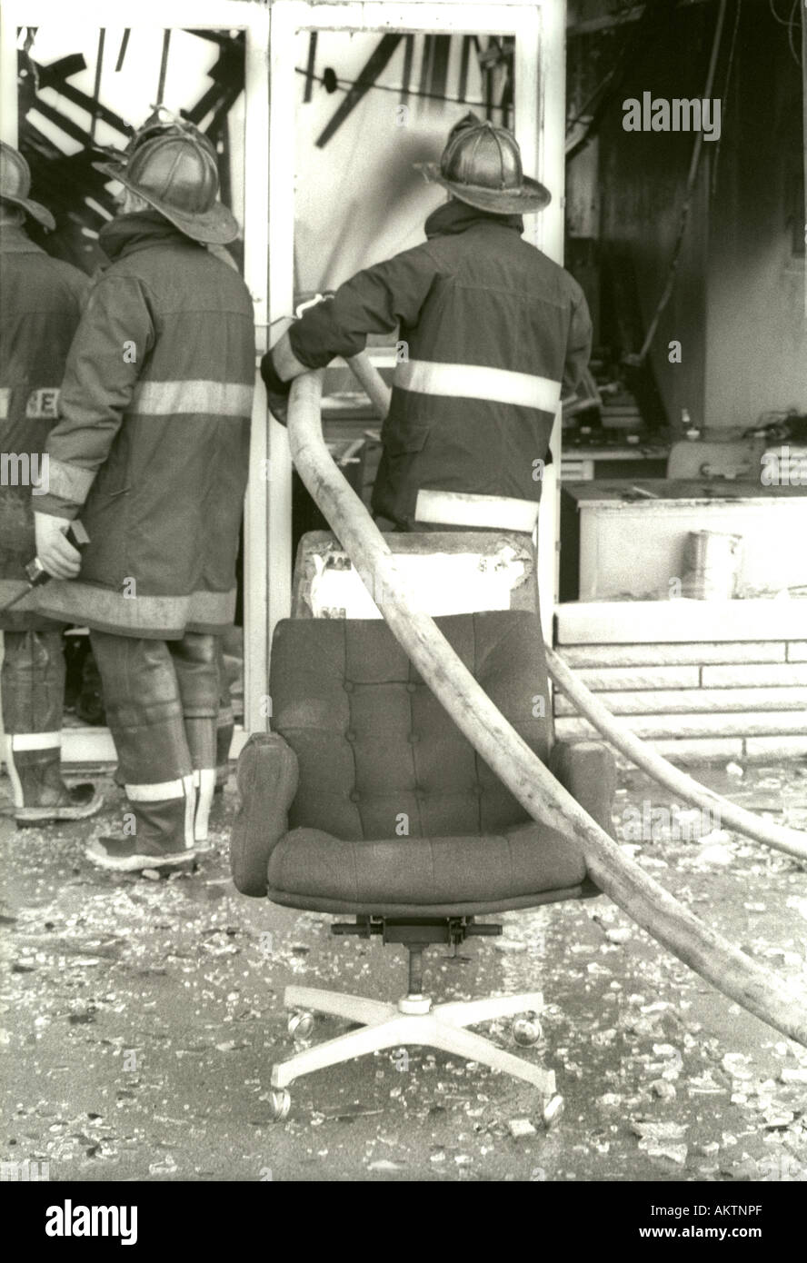 Firemen inspecting a building after the fire has been extinguished ...