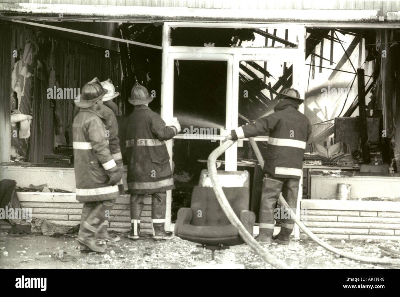 Firemen inspecting a building after the fire has been extinguished ...