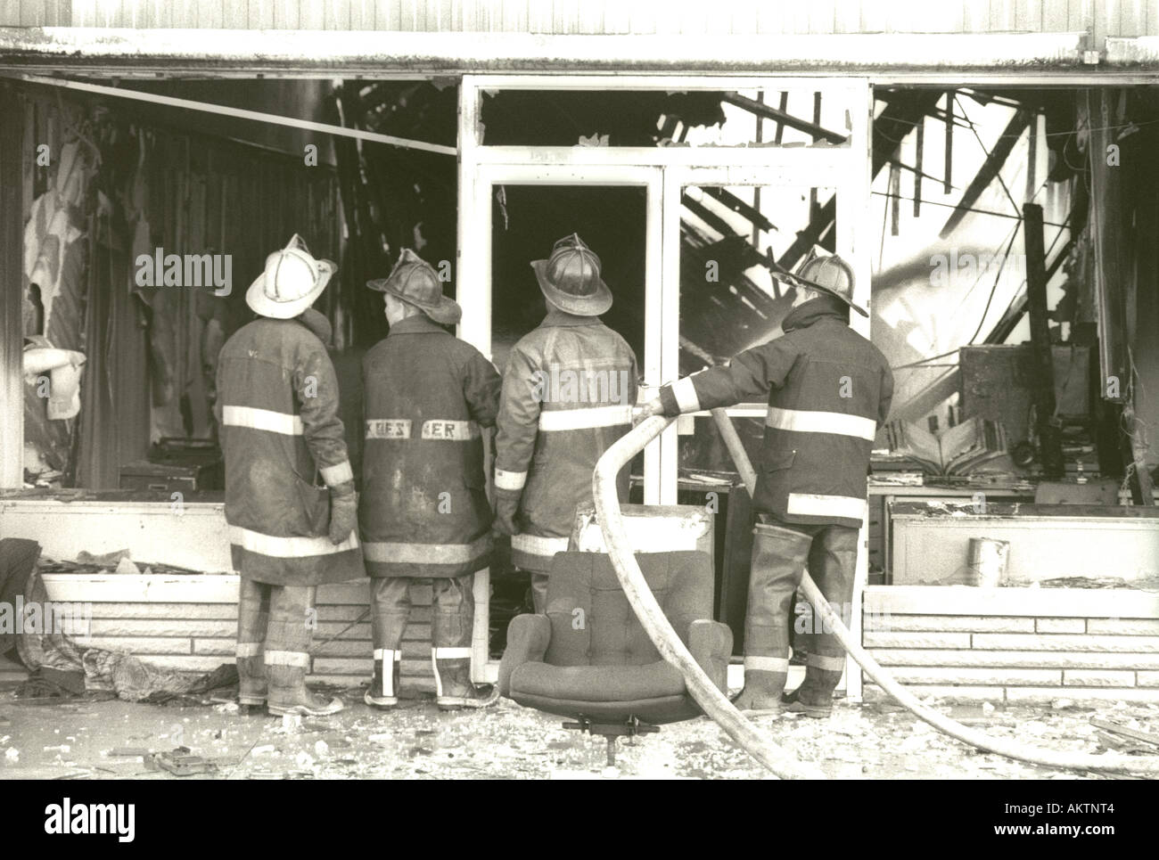 Firemen inspecting a building after the fire has been extinguished ...
