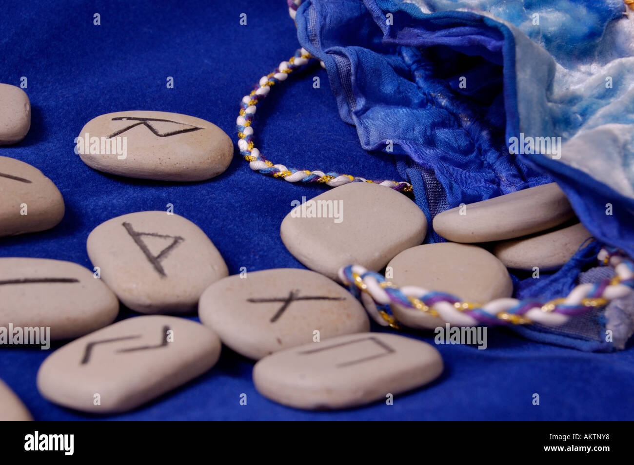 A bag of rune stones spread across a blue velvet surface for a reading ...