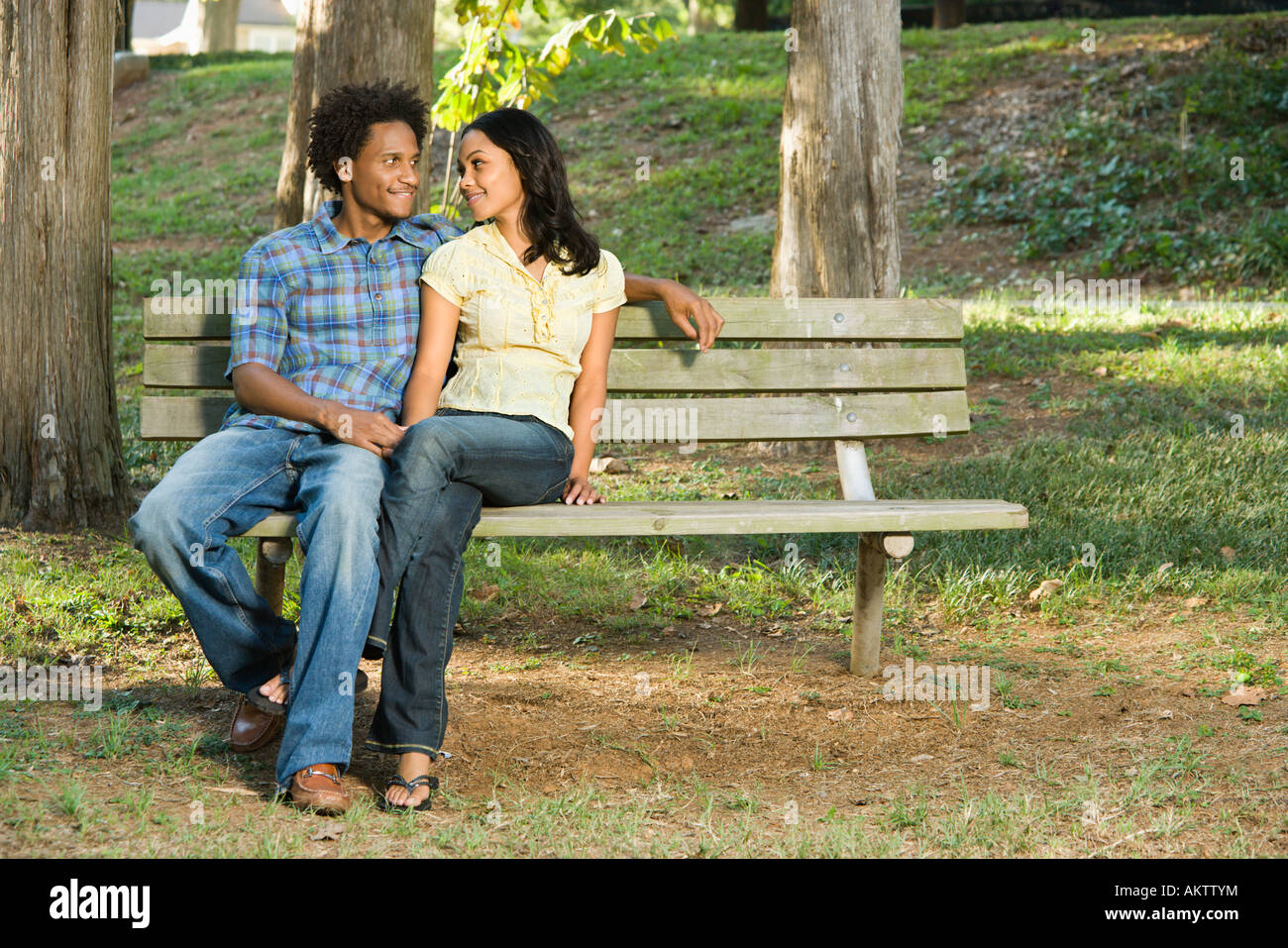 Happy smiling couple sitting on park bench together Stock Photo - Alamy