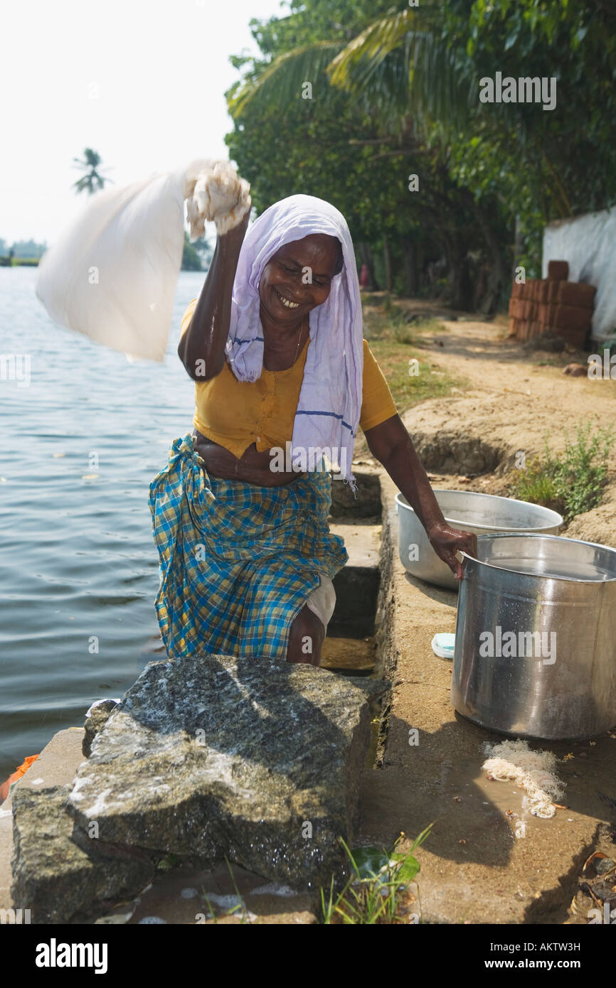 INDIA KERALA BACKWATERS WOMAN WASHING CLOTHES ON RIVERBANK Stock Photo ...