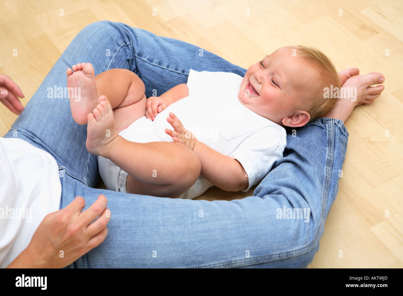 Baby Laying on Moms Legs Smiling Stock Photo - Alamy