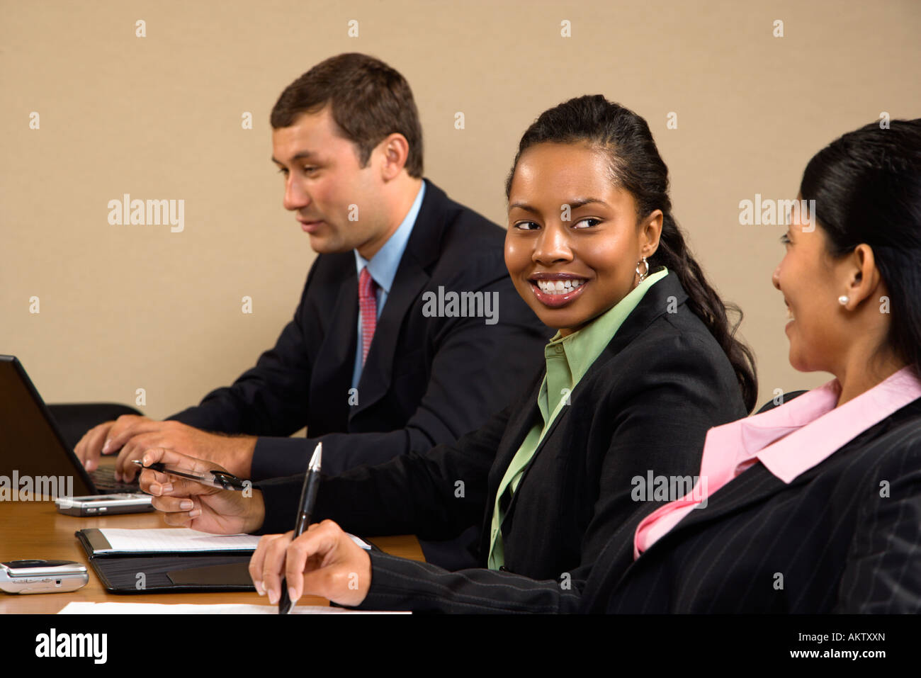 Businesspeople sitting at conference table talking and smiling Stock ...