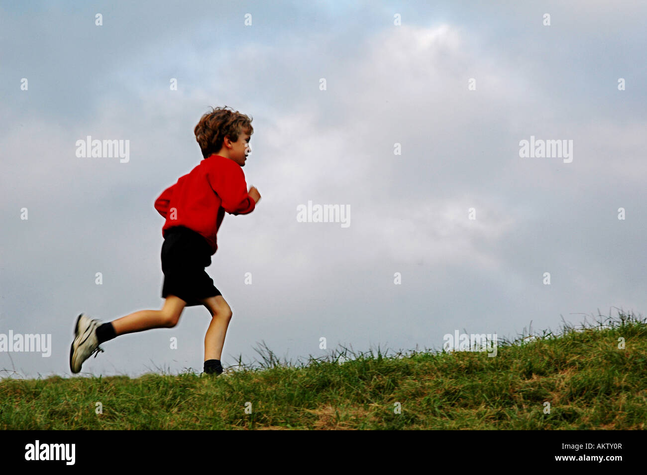 boy running up a hill Stock Photo - Alamy