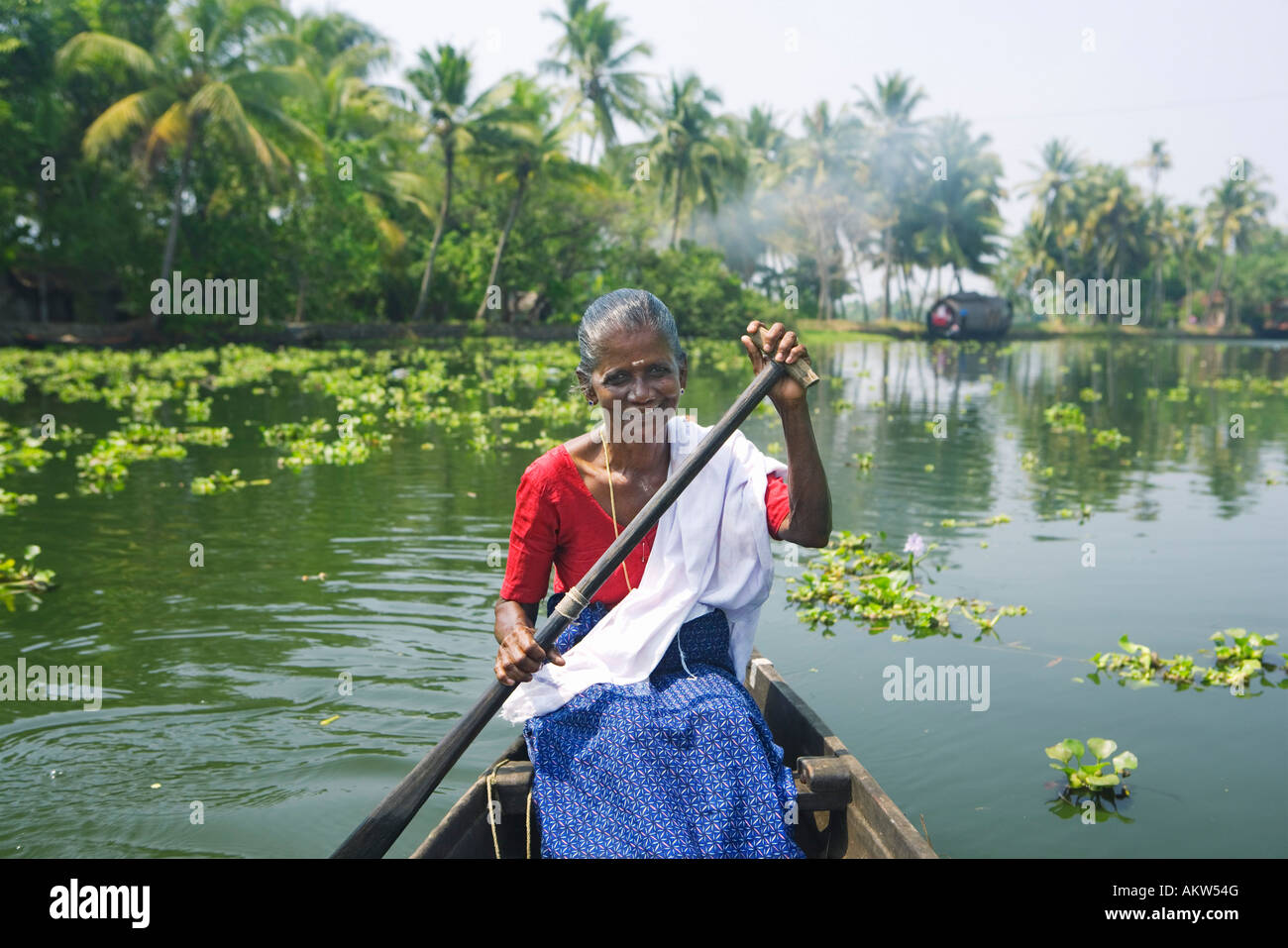 INDIA KERALA BACKWATERS WOMAN ROWING BOAT ON WATERWAYS Stock Photo - Alamy