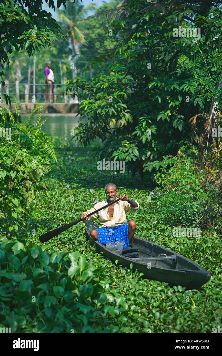 INDIA KERALA BACKWATERS MAN ROWING IN CANAL THROUGH LILIES Stock Photo ...