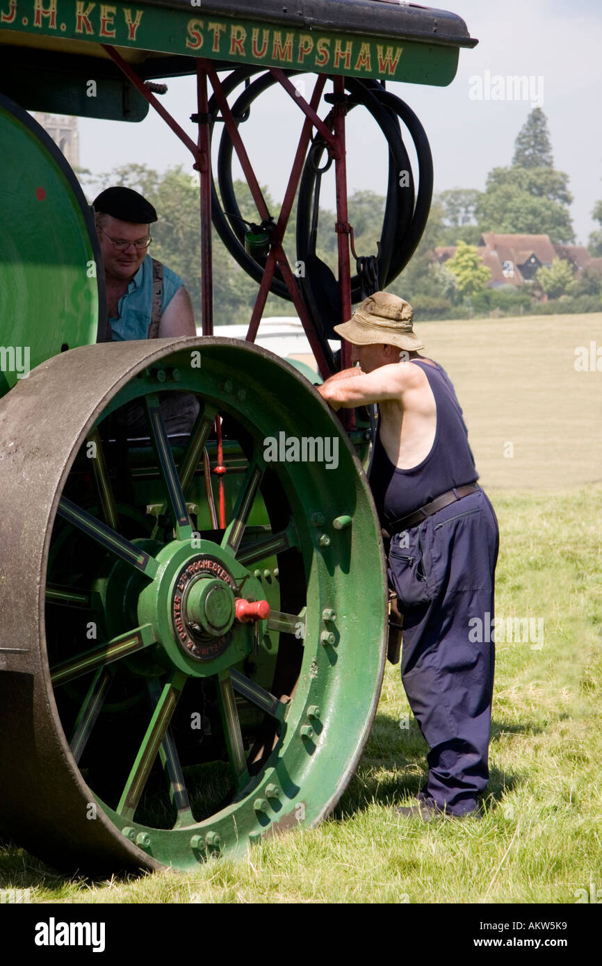 Two men in discussion by a a restored steam traction engine on display ...