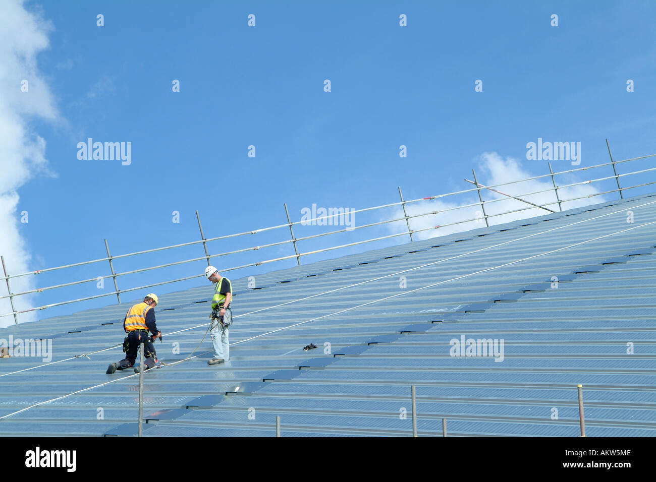 Construction workers working on the roof of a new building Stock Photo ...