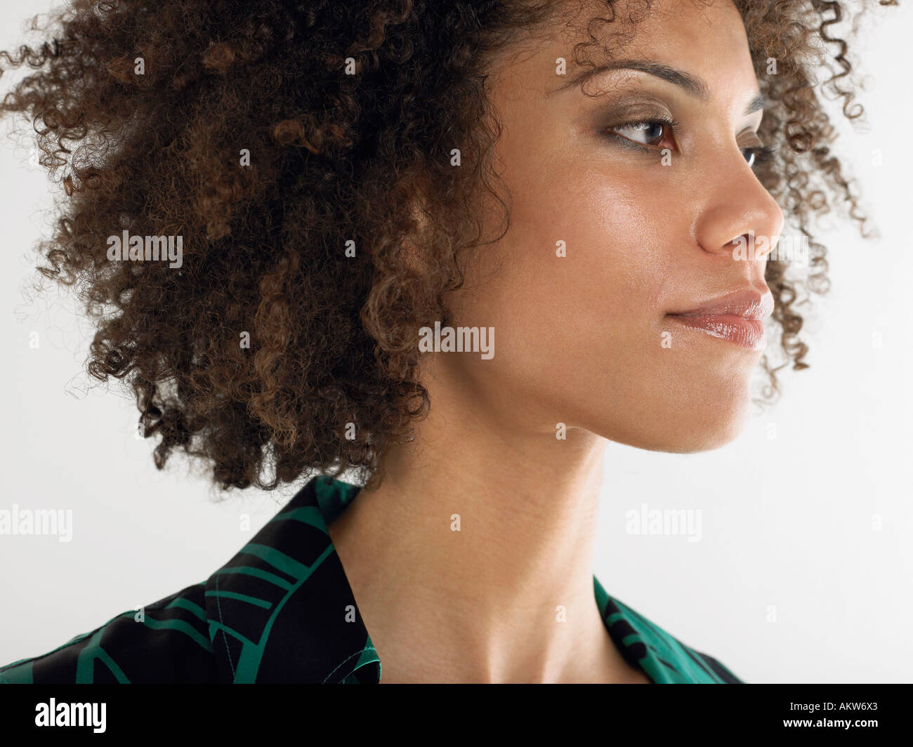 Woman with curly hair, head and shoulders in studio Stock Photo - Alamy