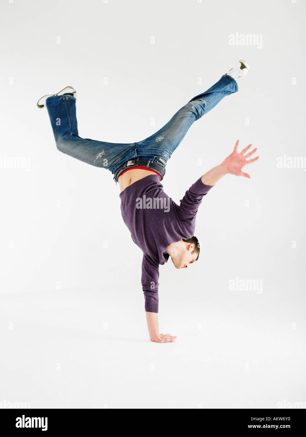 Man doing one handed handstand in studio Stock Photo - Alamy