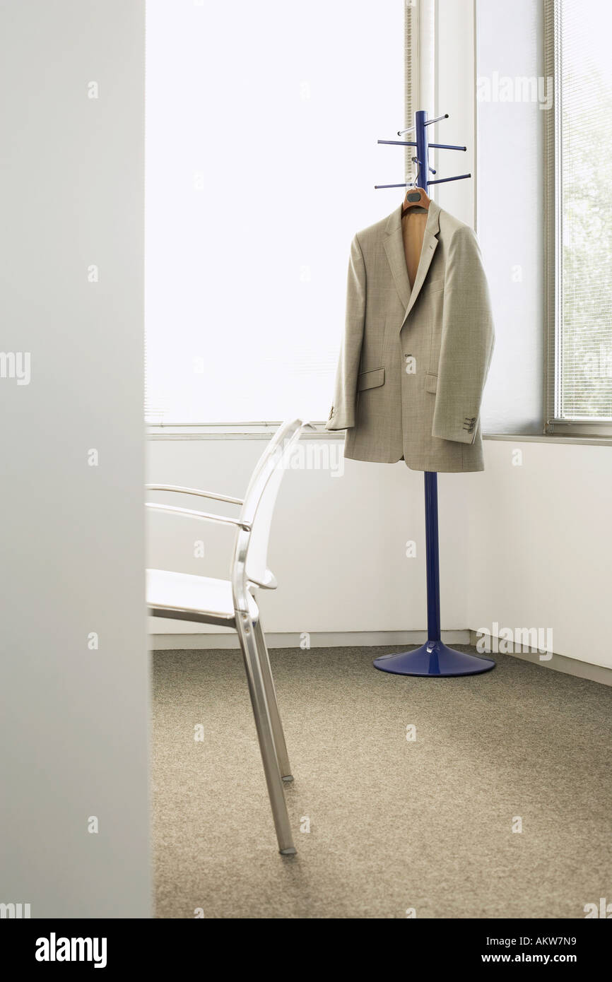 Suit jacket on coat stand in corner of office Stock Photo - Alamy